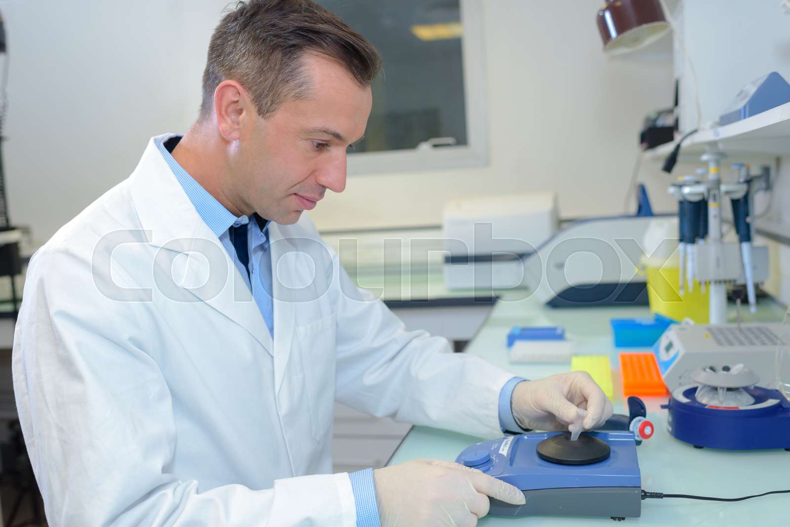Laboratory technician setting up equipment | Stock image | Colourbox