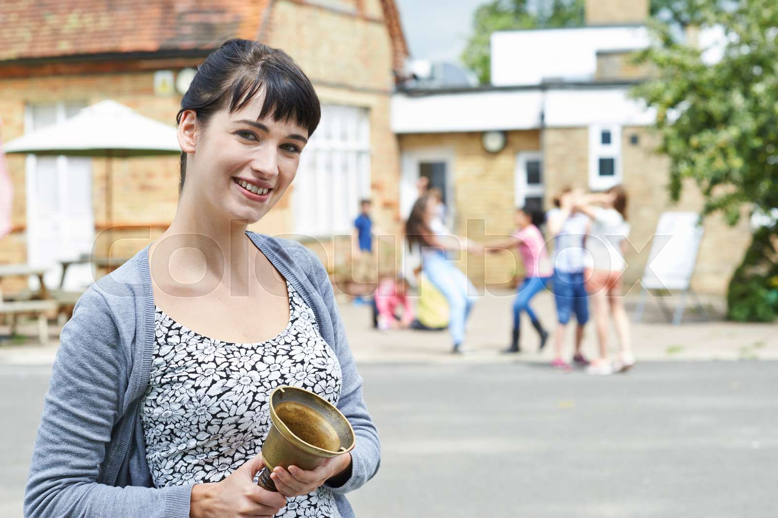 Portrait Of Teacher With Bell Supervising Break In School Playground ...