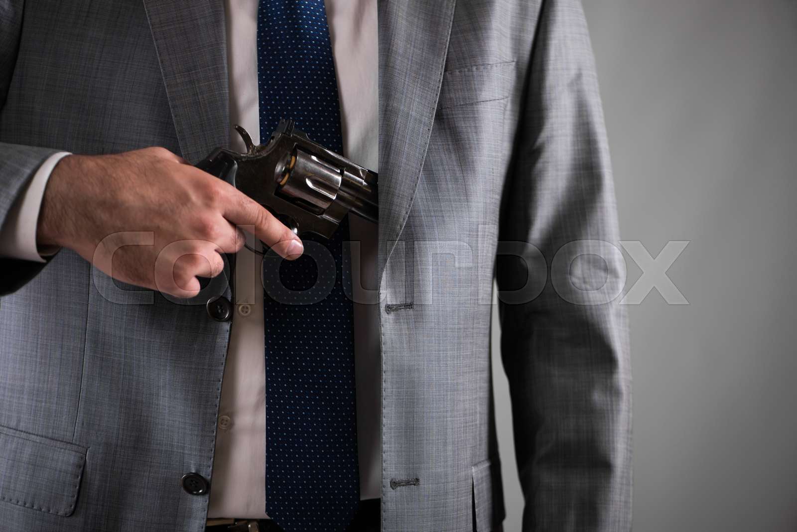 Man pulling out gun from his pocket | Stock image | Colourbox