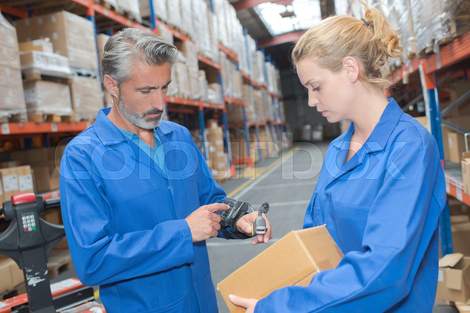 Man scanning box with computerized scanner | Stock image | Colourbox