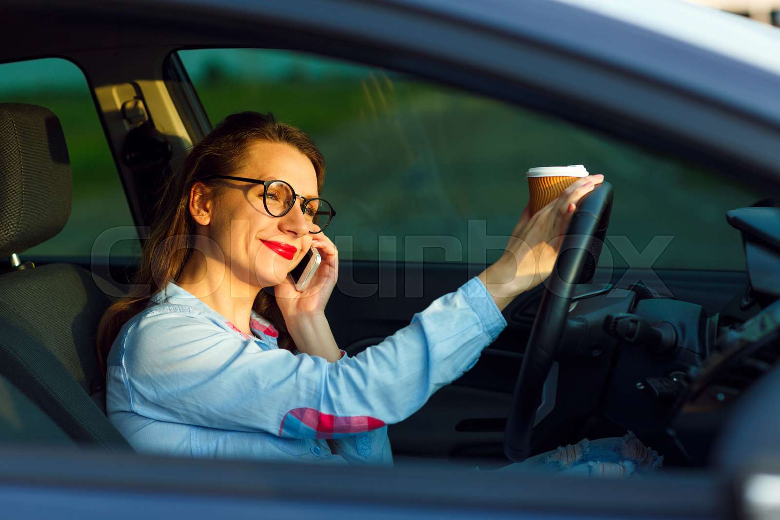 Businesswoman multitasking while driving | Stock image | Colourbox