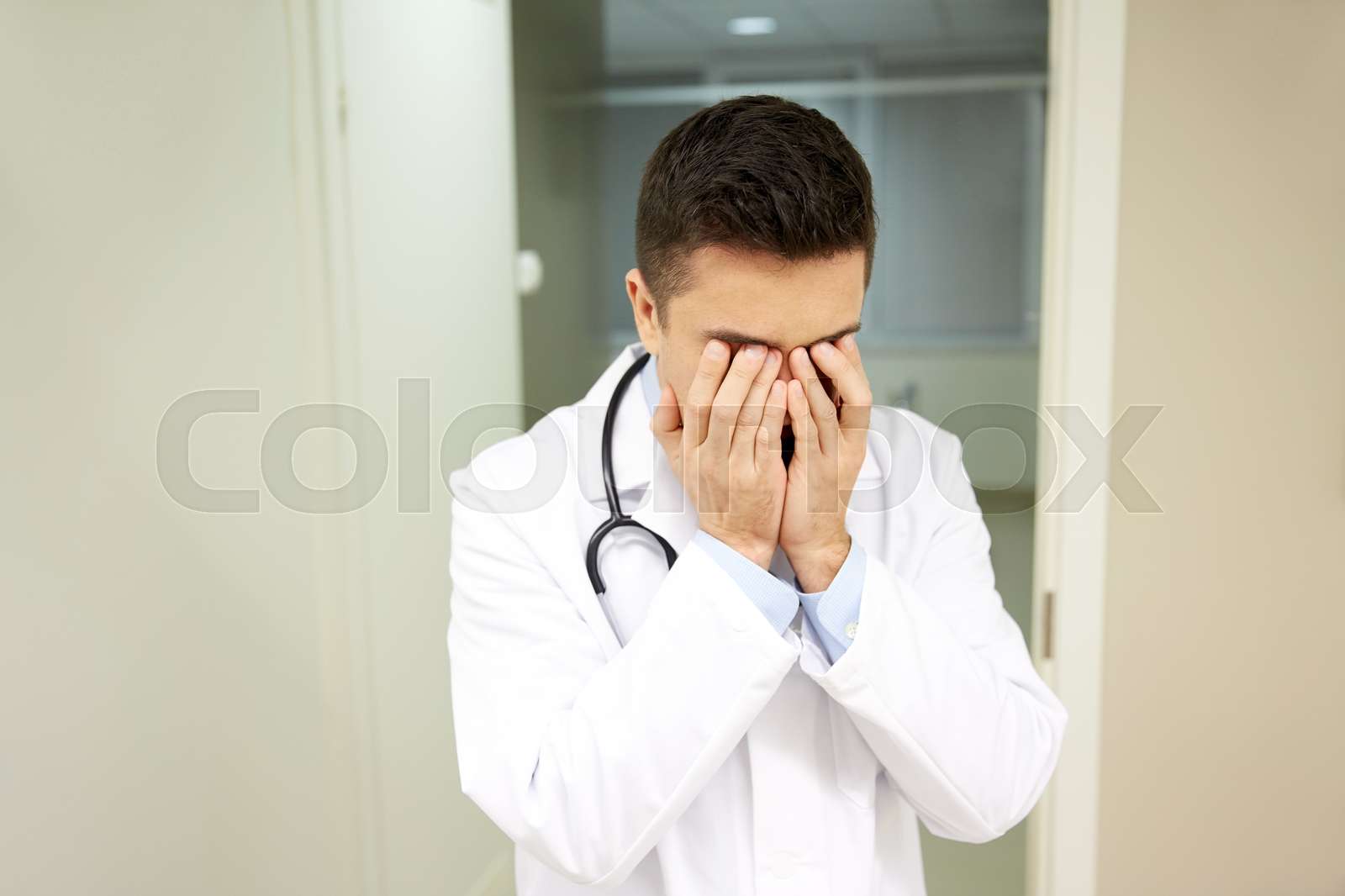 sad or crying male doctor at hospital ward | Stock image | Colourbox