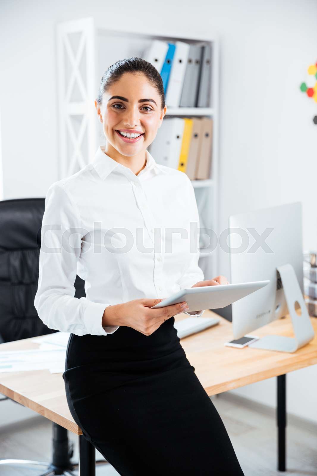 Businesswoman leaning on the office desk and using pc tablet | Stock ...