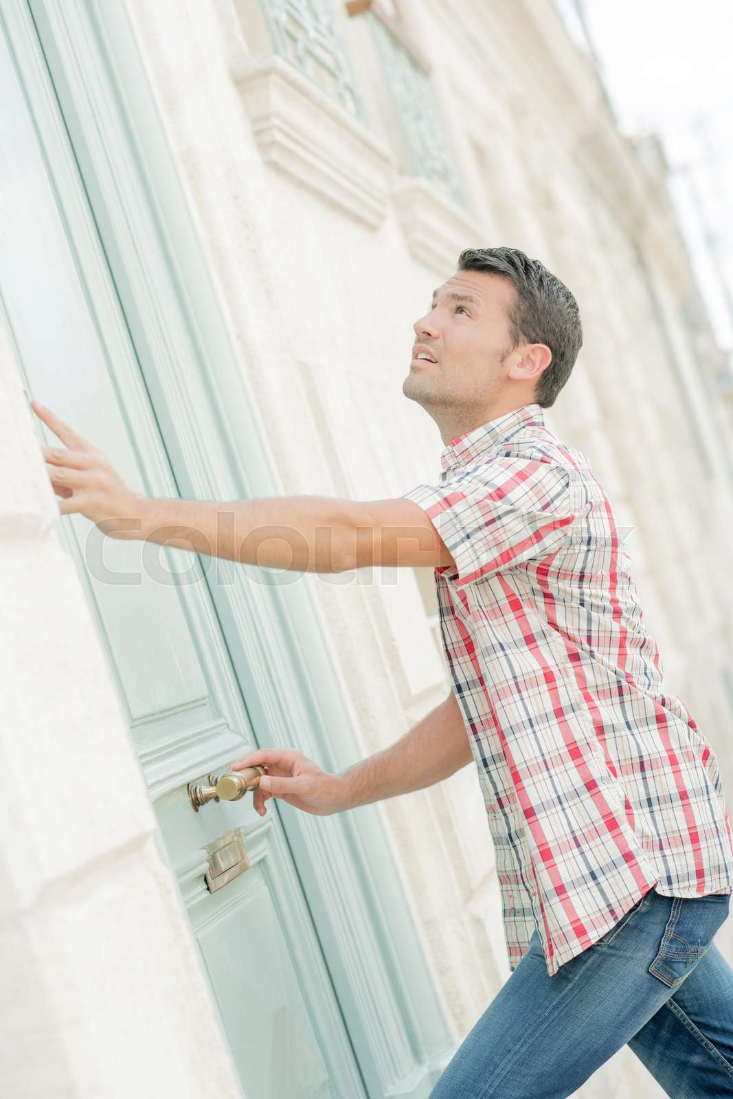 Man ringing a door bell | Stock image | Colourbox