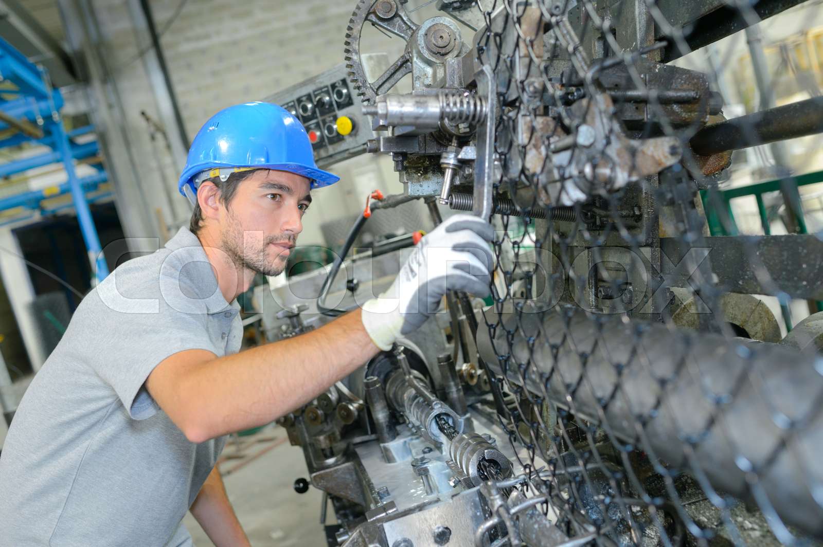Factory worker adjusting machine with wrench | Stock image | Colourbox