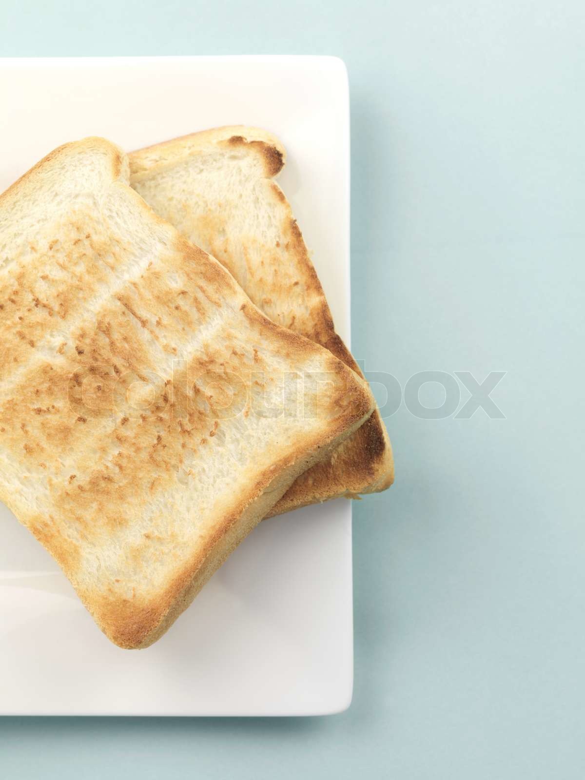 Plain hvid toast isoleret mod en lyseblå baggrund | Stock foto | Colourbox