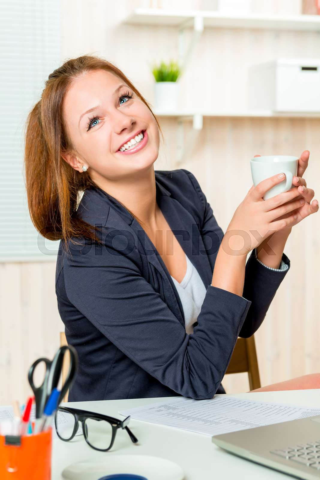 secretary happy with a cup of coffee dreaming about something in the ...