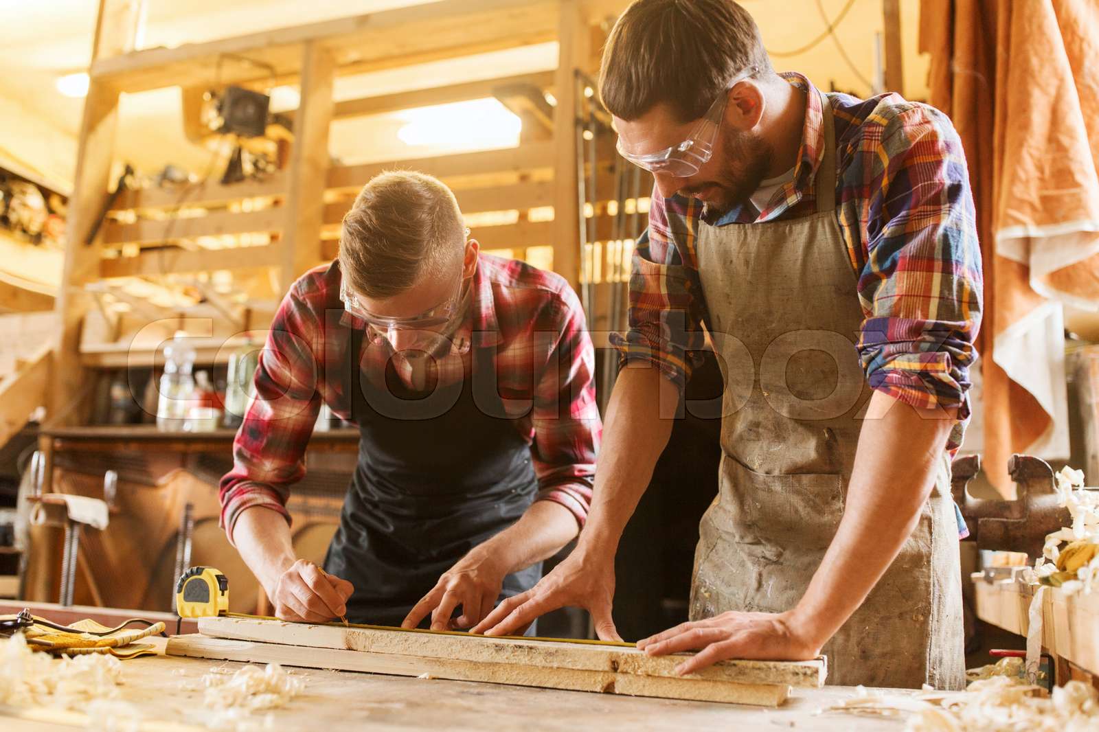 carpenters with ruler and wood plank at workshop | Stock image | Colourbox