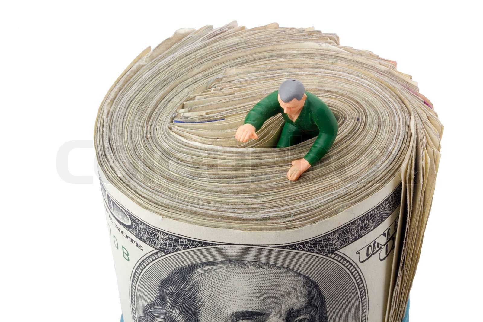 Miniature man drowning in a roll of American money. | Stock image ...