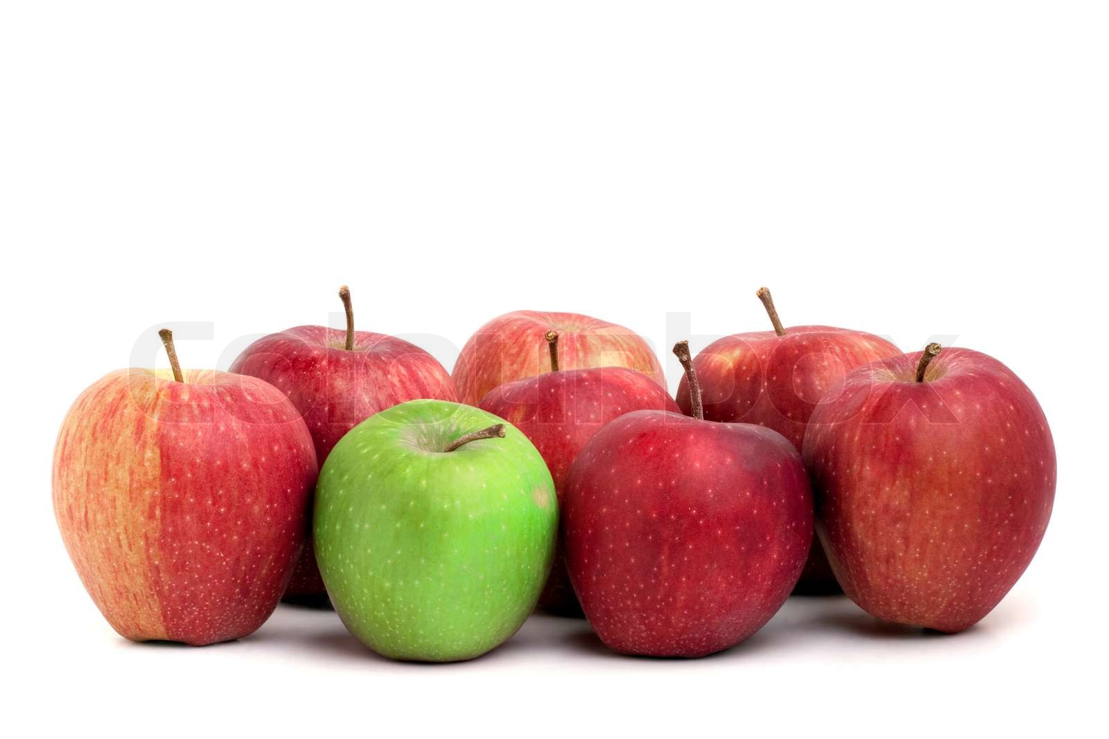Ein einsamer grüner Granny Smith Apfel sitzt unter einer Menge von red ...
