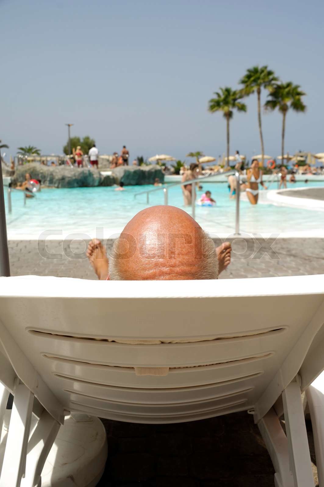Bald headed man relaxing by the pool | Stock image | Colourbox