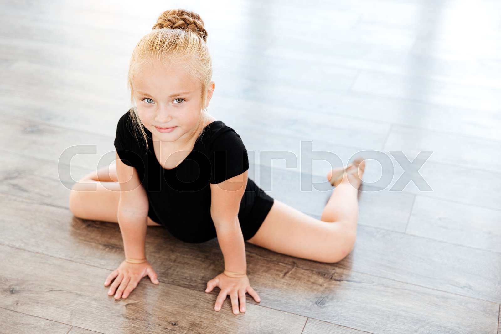 Little girl ballerina stretching in dance studio | Stock image | Colourbox