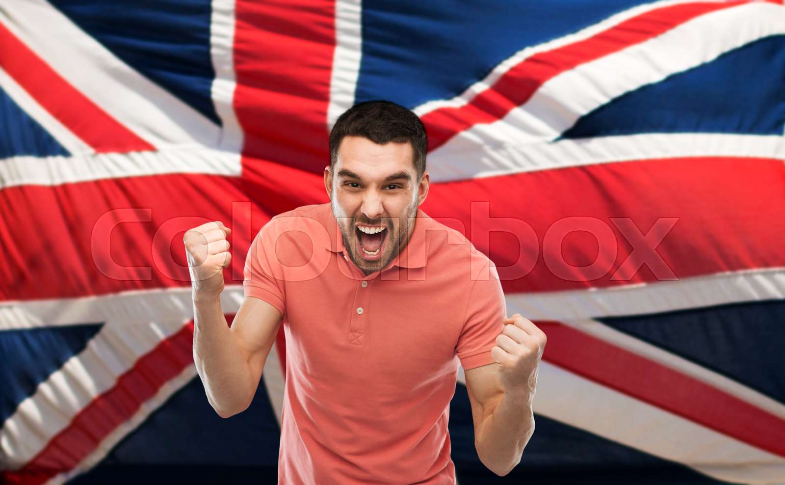 angry man showing fists over brittish flag | Stock image | Colourbox
