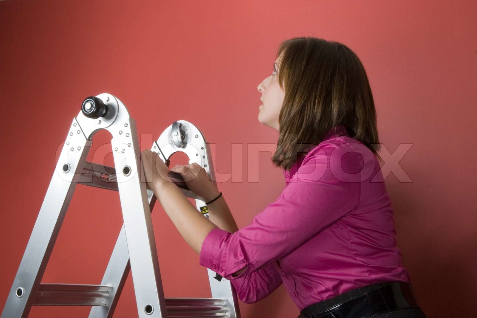 Eine junge Frau steigt an die Spitze dieser symbolischen Karriereleiter. | Stock Bild | Colourbox