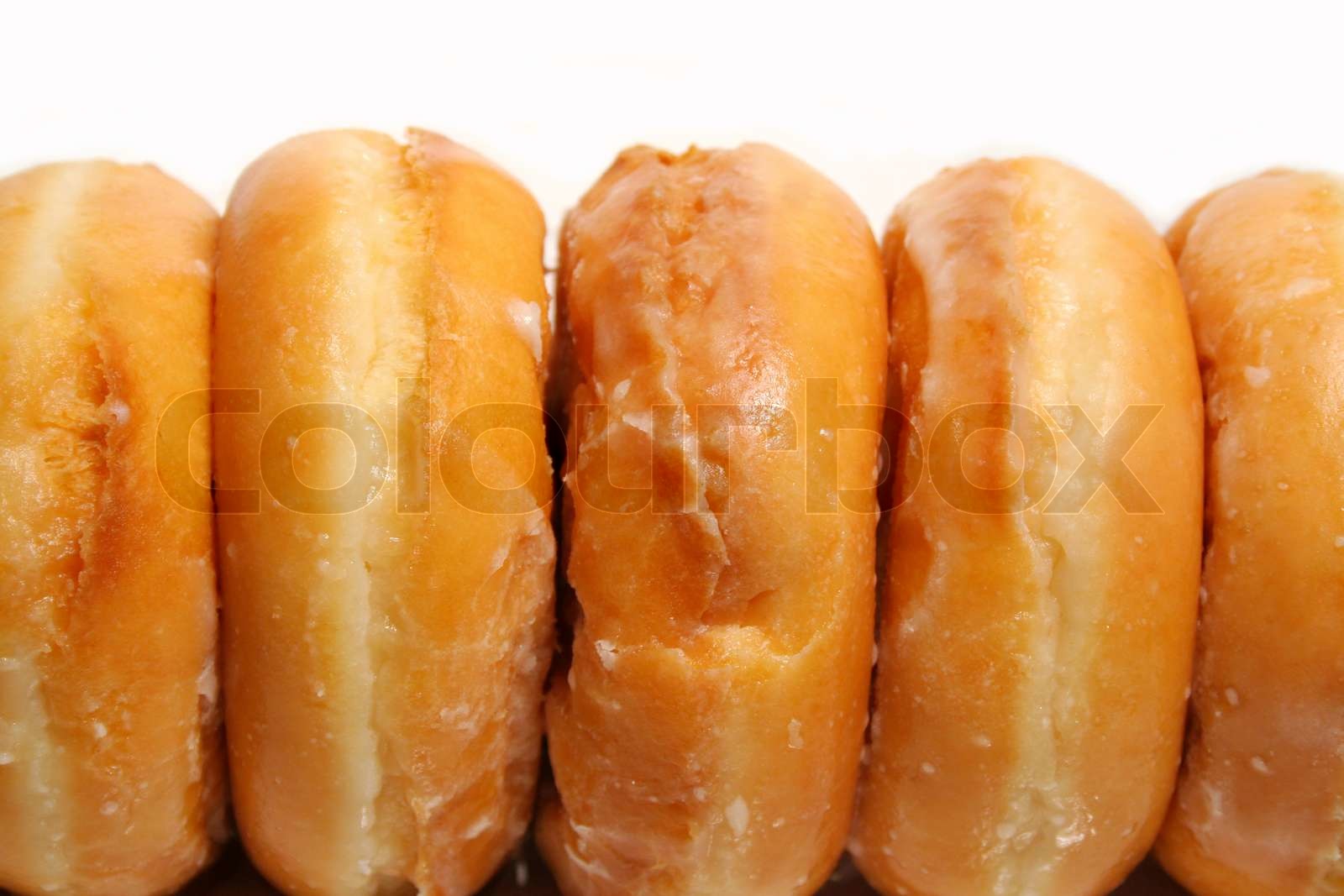 Row of donuts glazed with icing | Stock image | Colourbox