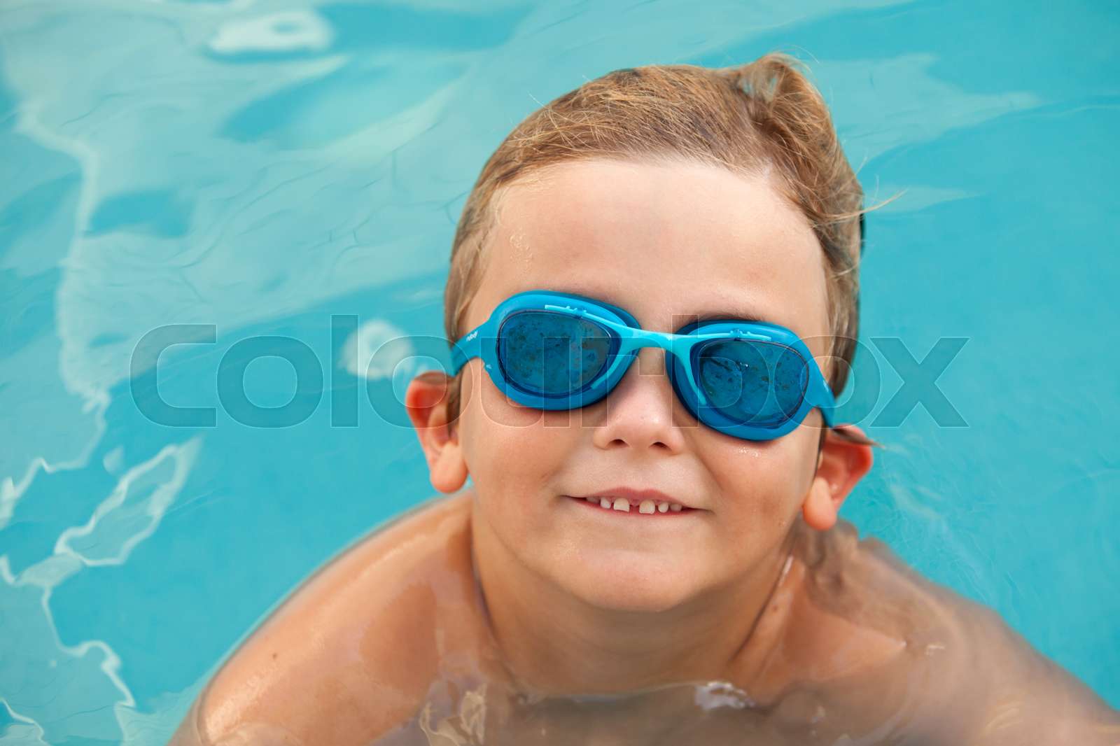 Funny kid cooling off in the pool | Stock image | Colourbox