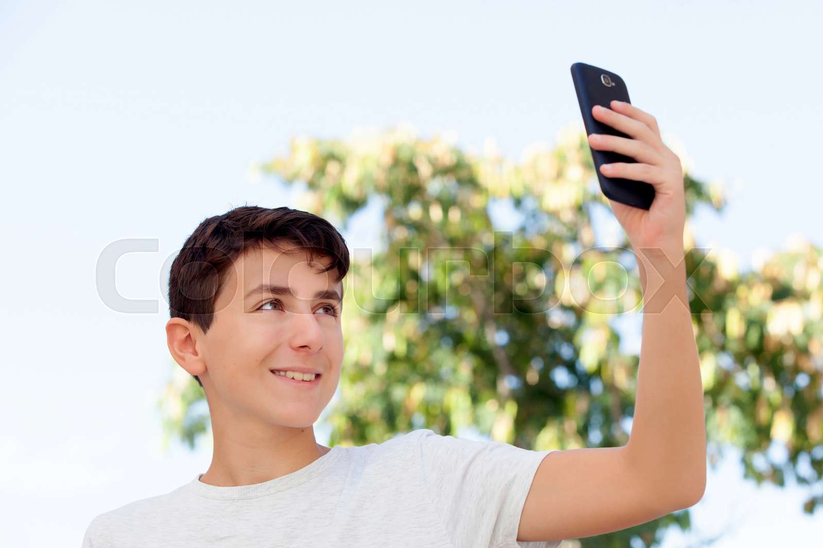 Teen boy getting a photo with the phone | Stock image | Colourbox