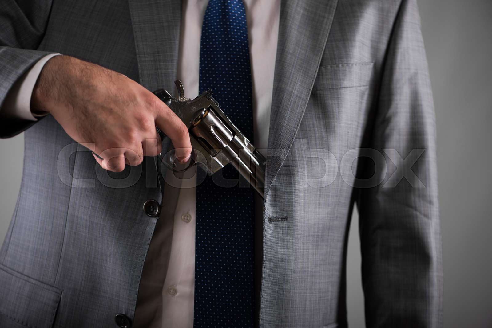 Man pulling out gun from his pocket | Stock image | Colourbox