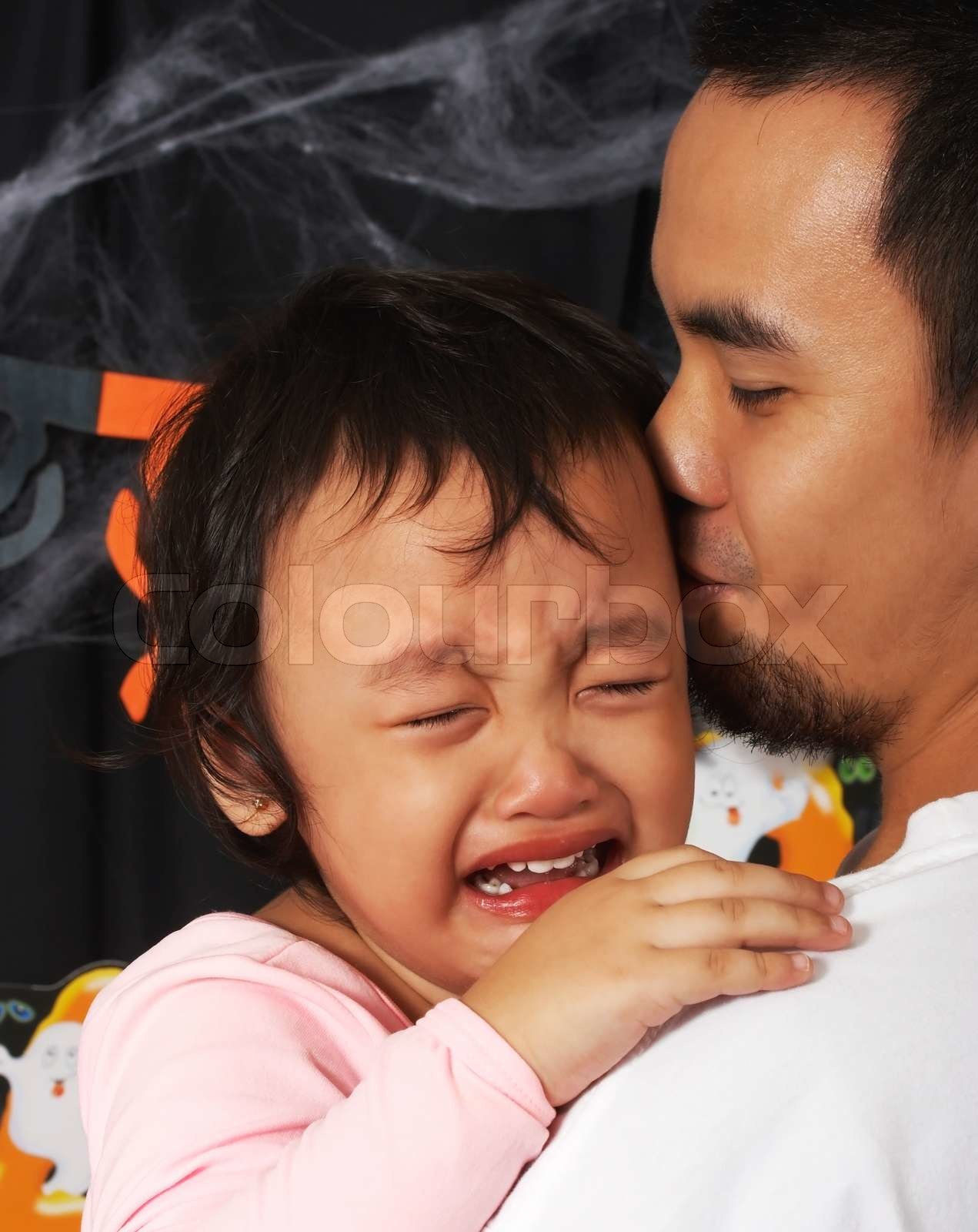 Father Cuddling And Comforting His Crying Child | Stock image | Colourbox