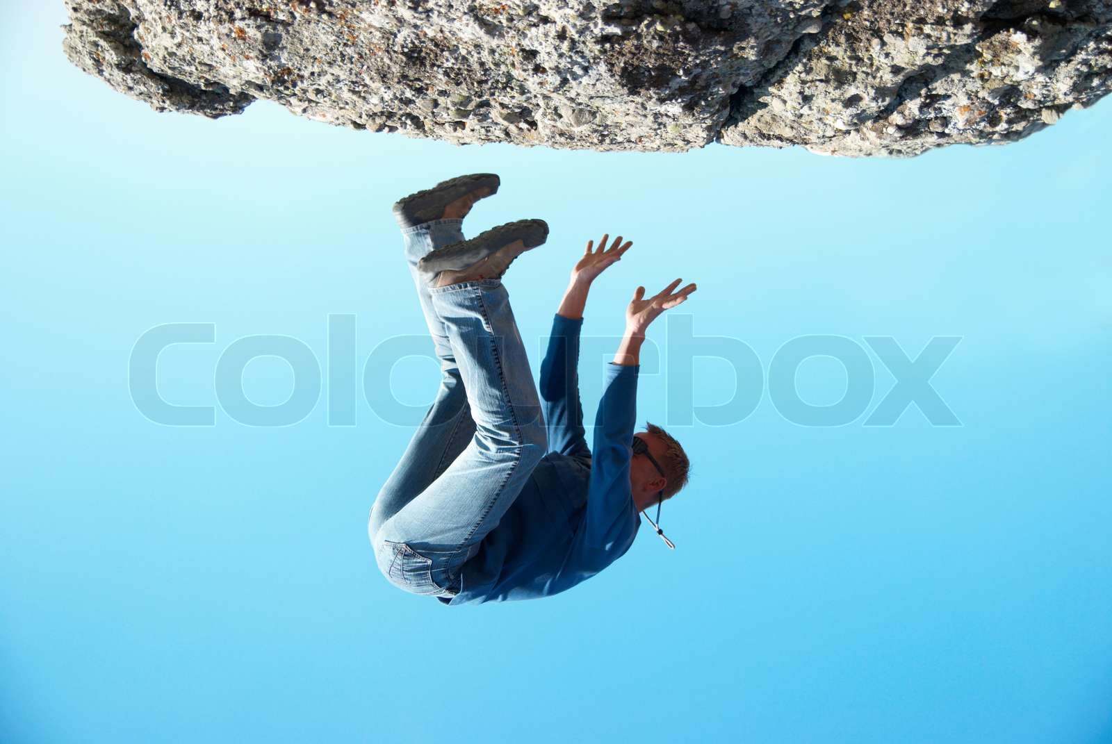 Falder ned mand fra klippen med blå baggrund | Stock foto | Colourbox