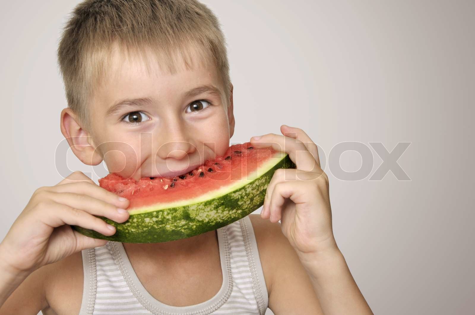 Sjov og glad lille dreng spiser vandmelon | Stock foto | Colourbox