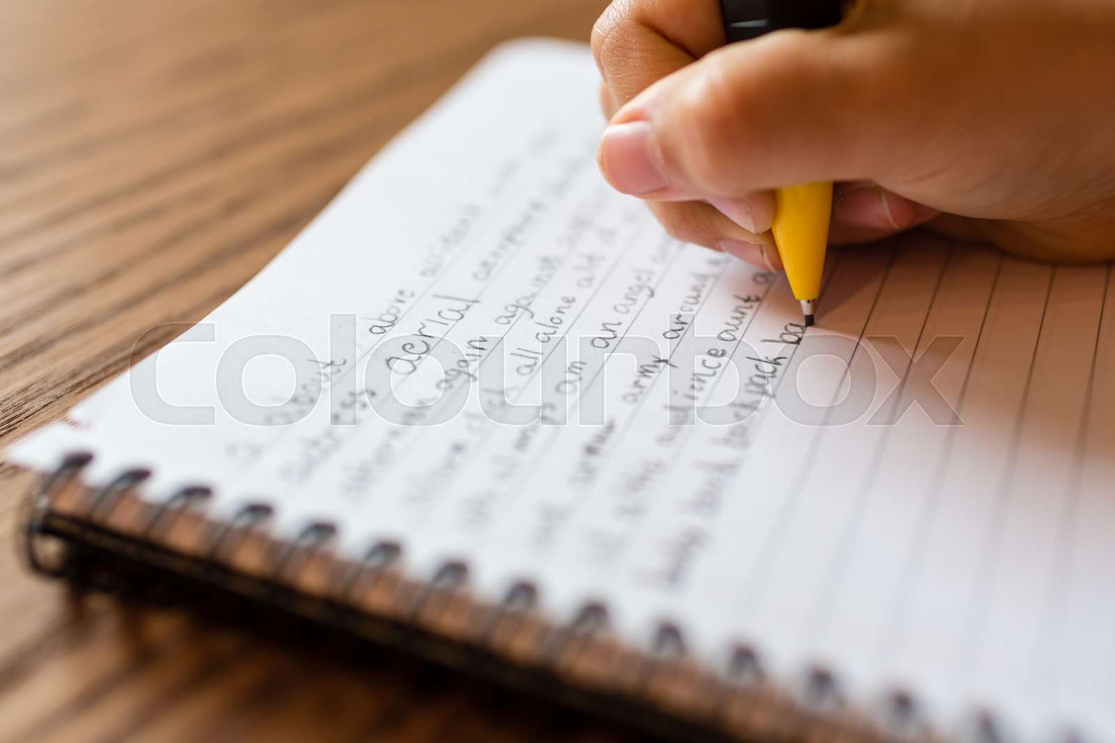 Girl writing by hand on notepad | Stock image | Colourbox