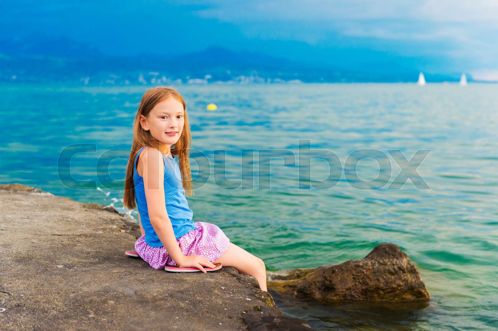 Cute little girl playing by the lake in the evening | Stock image ...
