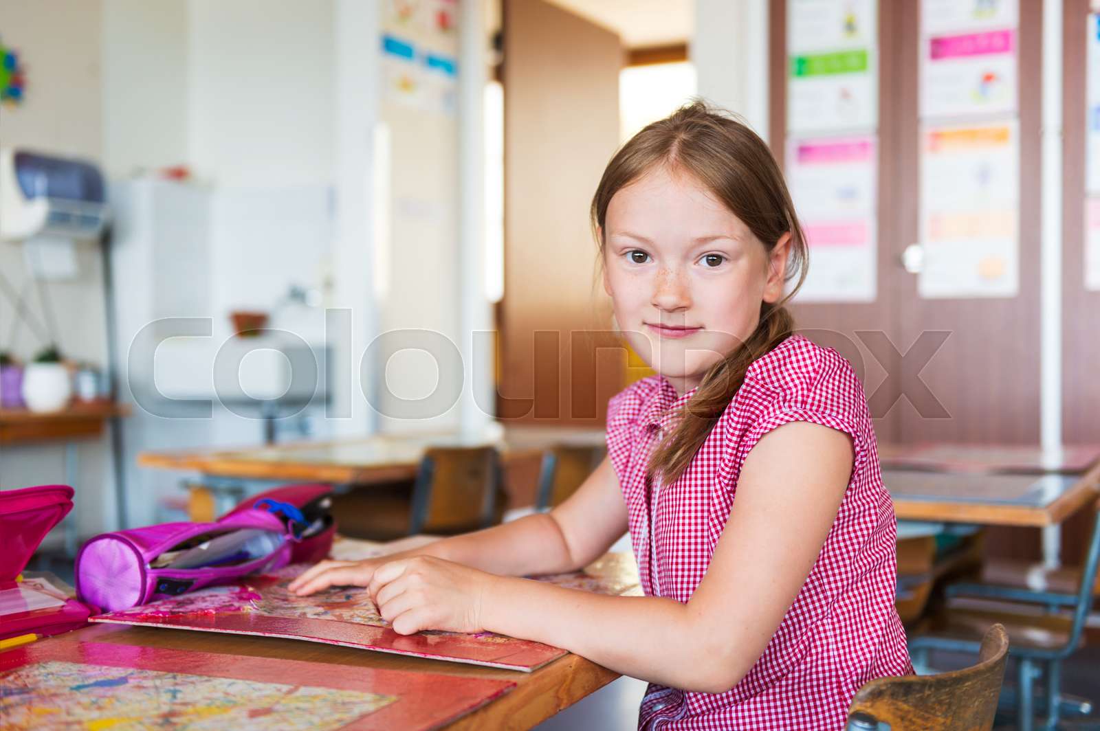 Indoor portrait of a cute little girl in a classroom | Stock image ...