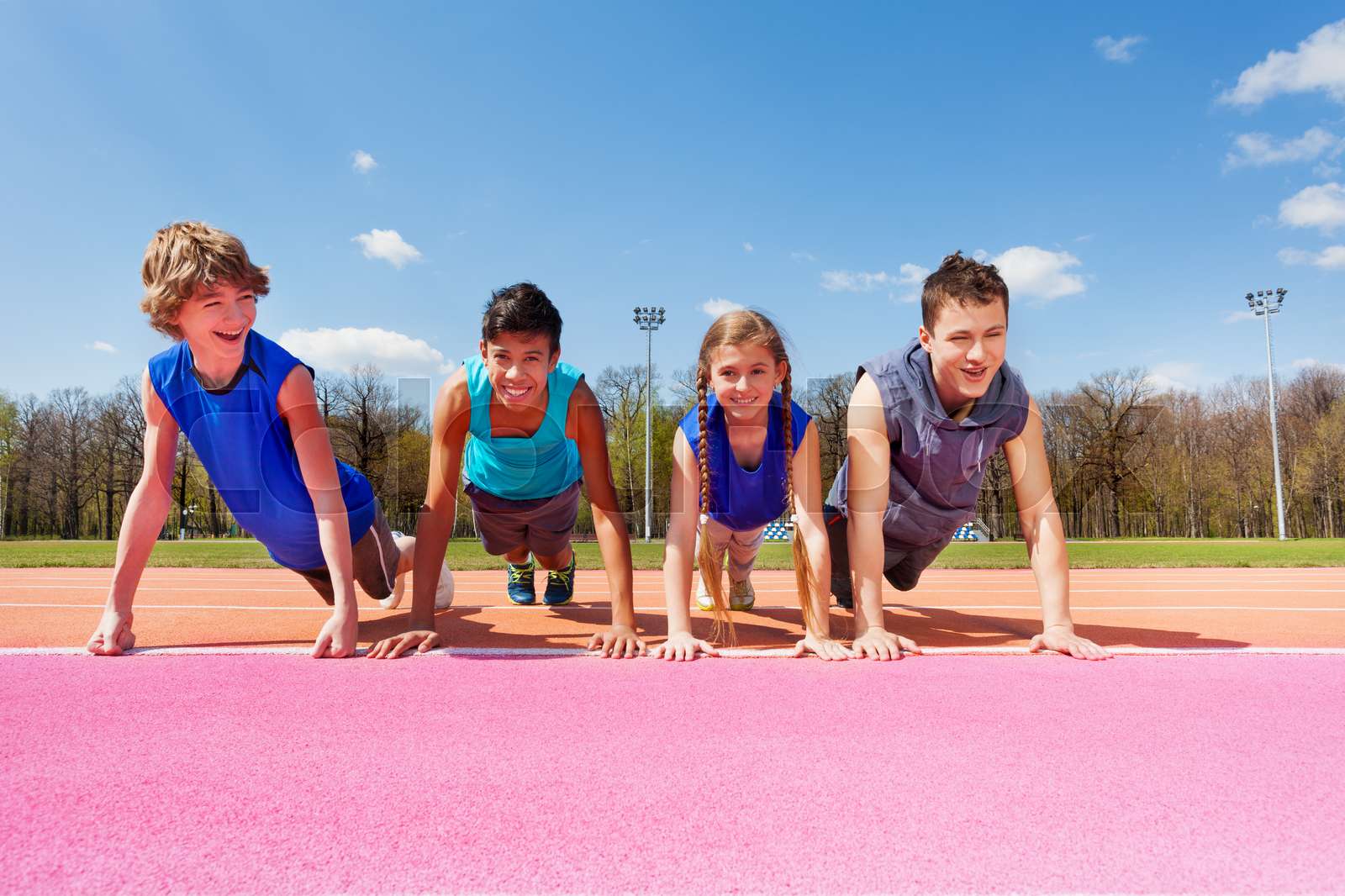 Happy teenagers doing push-up exercises outdoor | Stock image | Colourbox