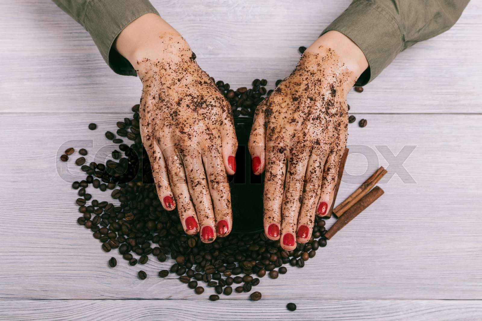 Women showing hands with red manicure and coated coffee scrub | Stock ...