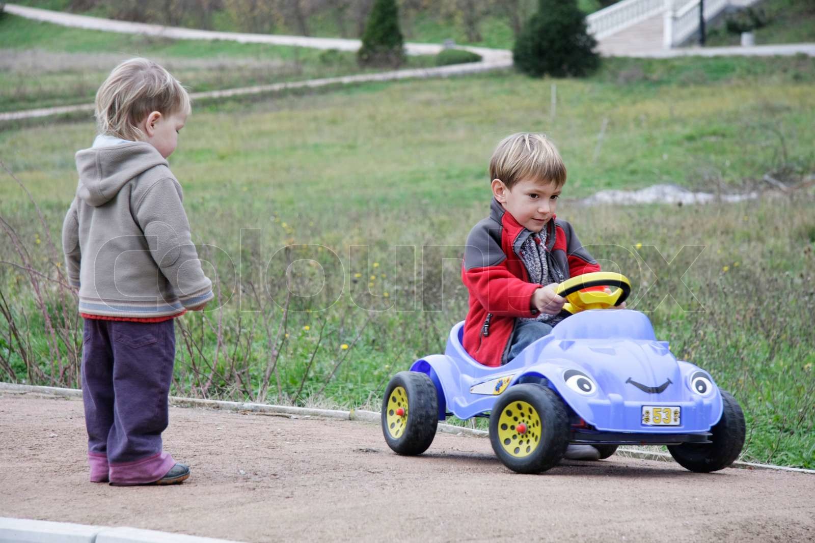 two children playing with toy car outdoors | Stock image | Colourbox