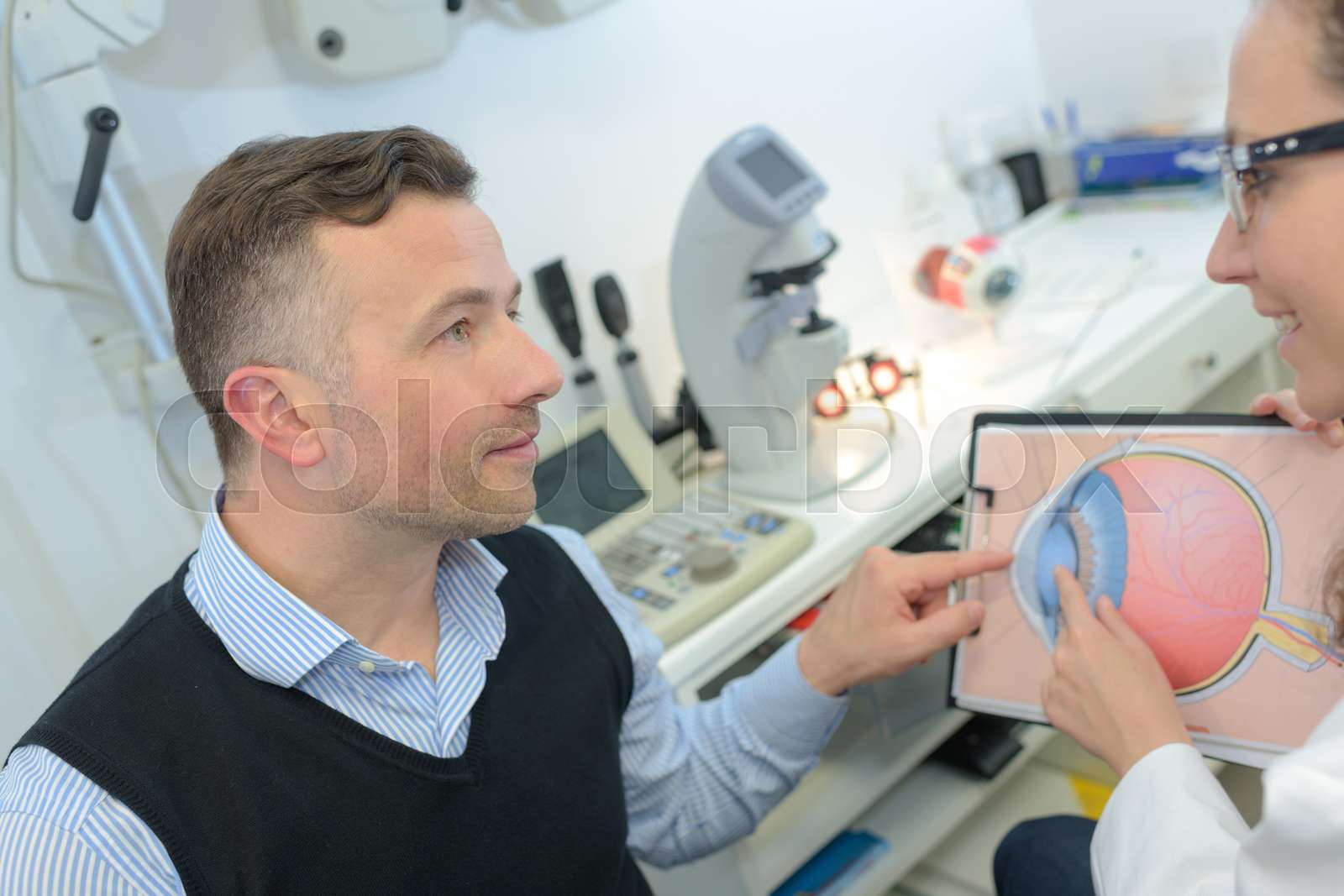 doctor explaining eye functioning to patient | Stock image | Colourbox