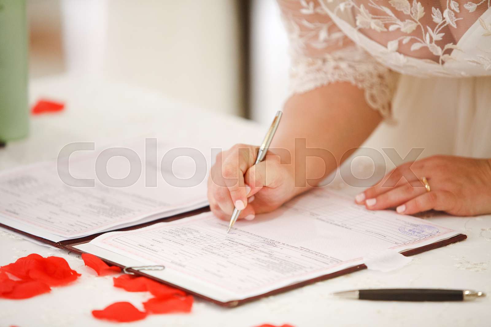 bride signs marriage certificate with a pen | Stock image | Colourbox