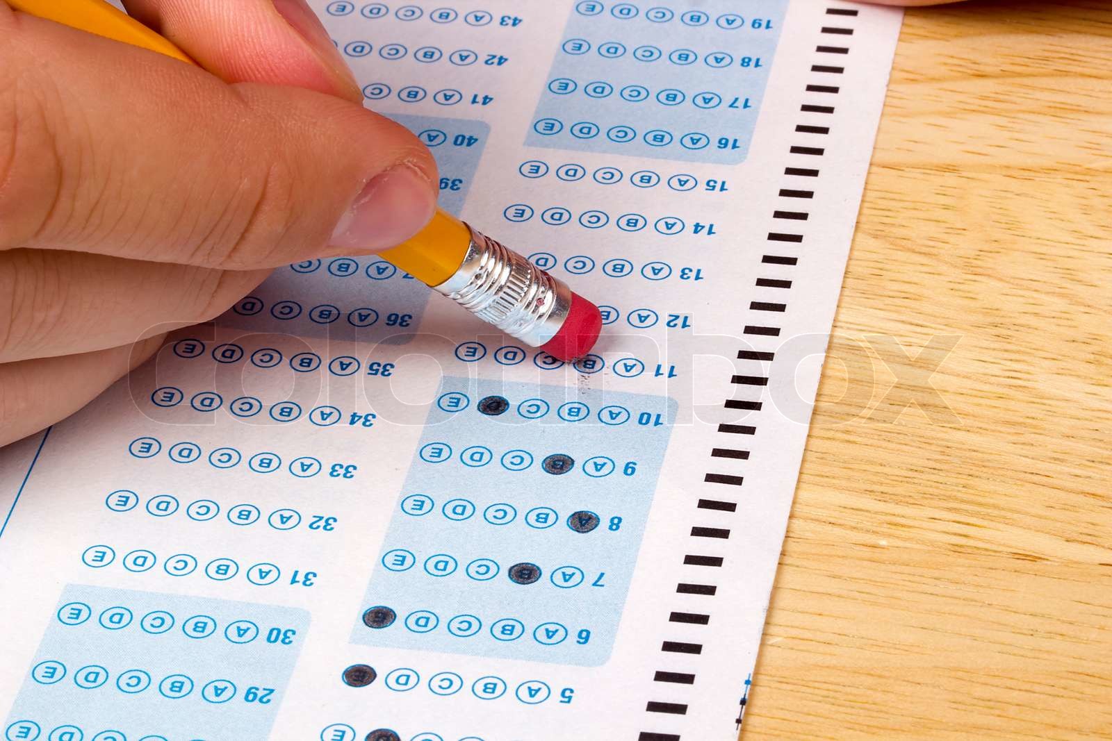 Student erasing a mistake he made on a test. | Stock image | Colourbox