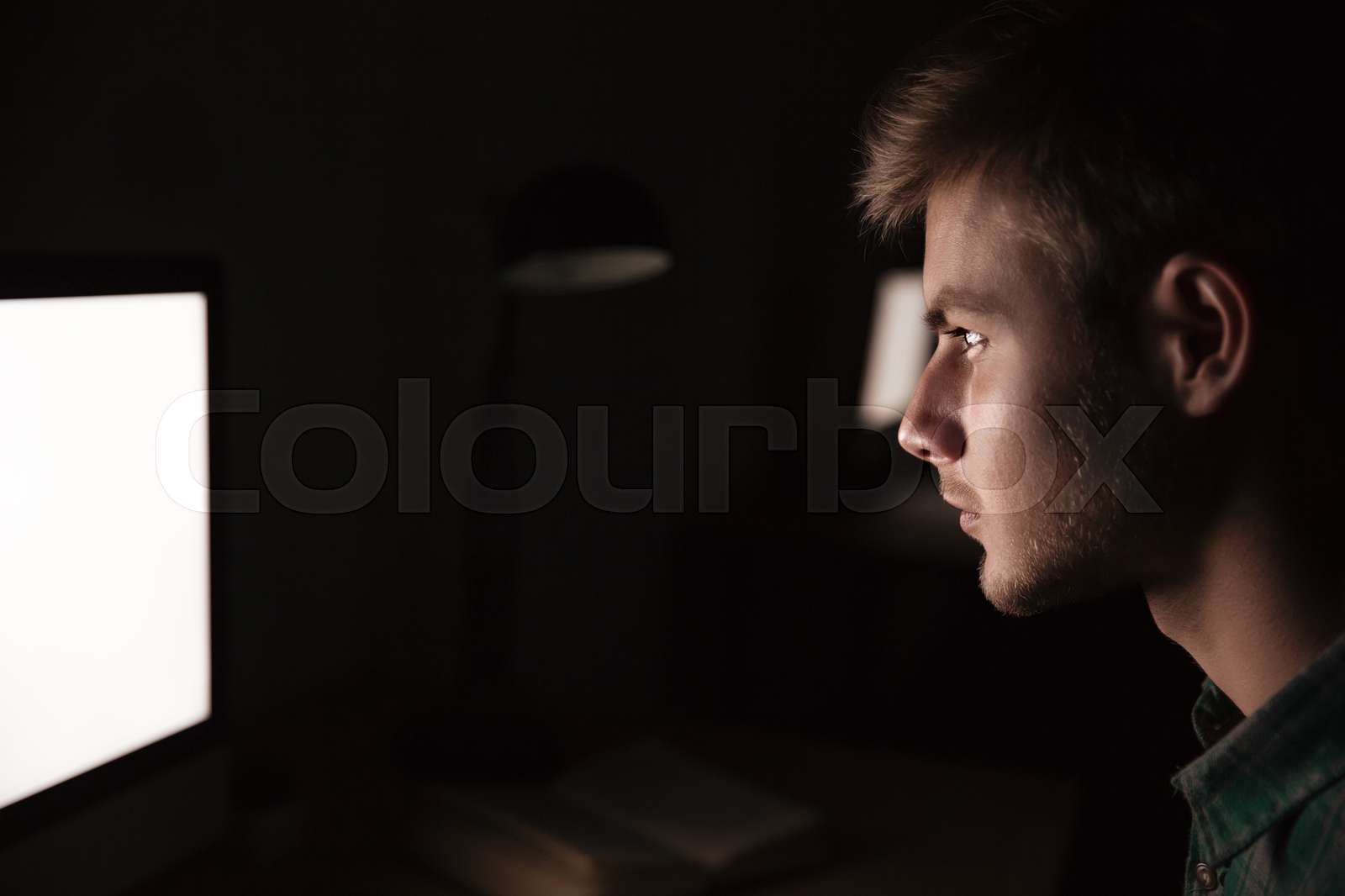 Man using blank screen computer in the dark room | Stock image | Colourbox