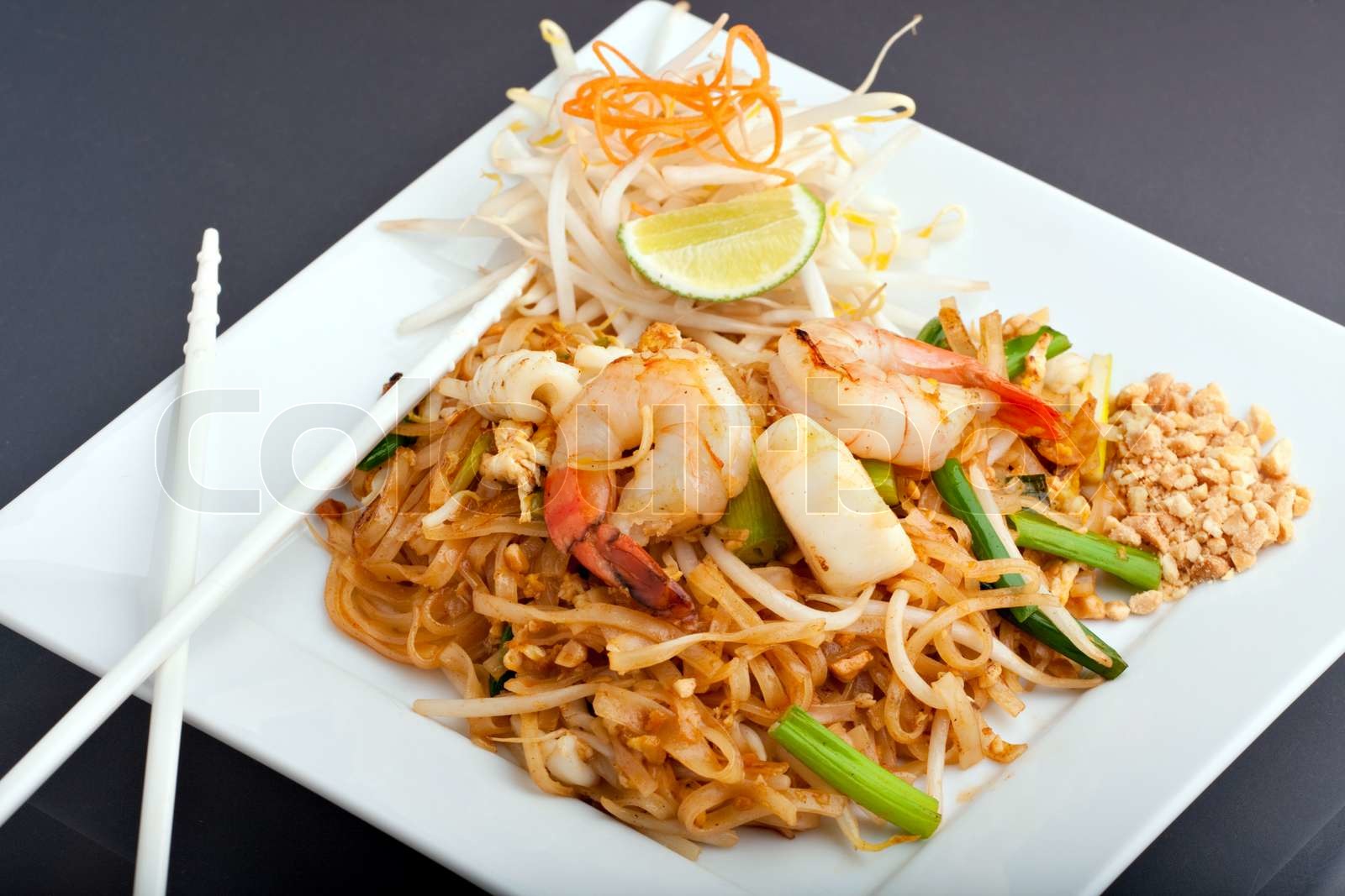 Seafood pad Thai dish of Thai fried rice noodles on a square white ...
