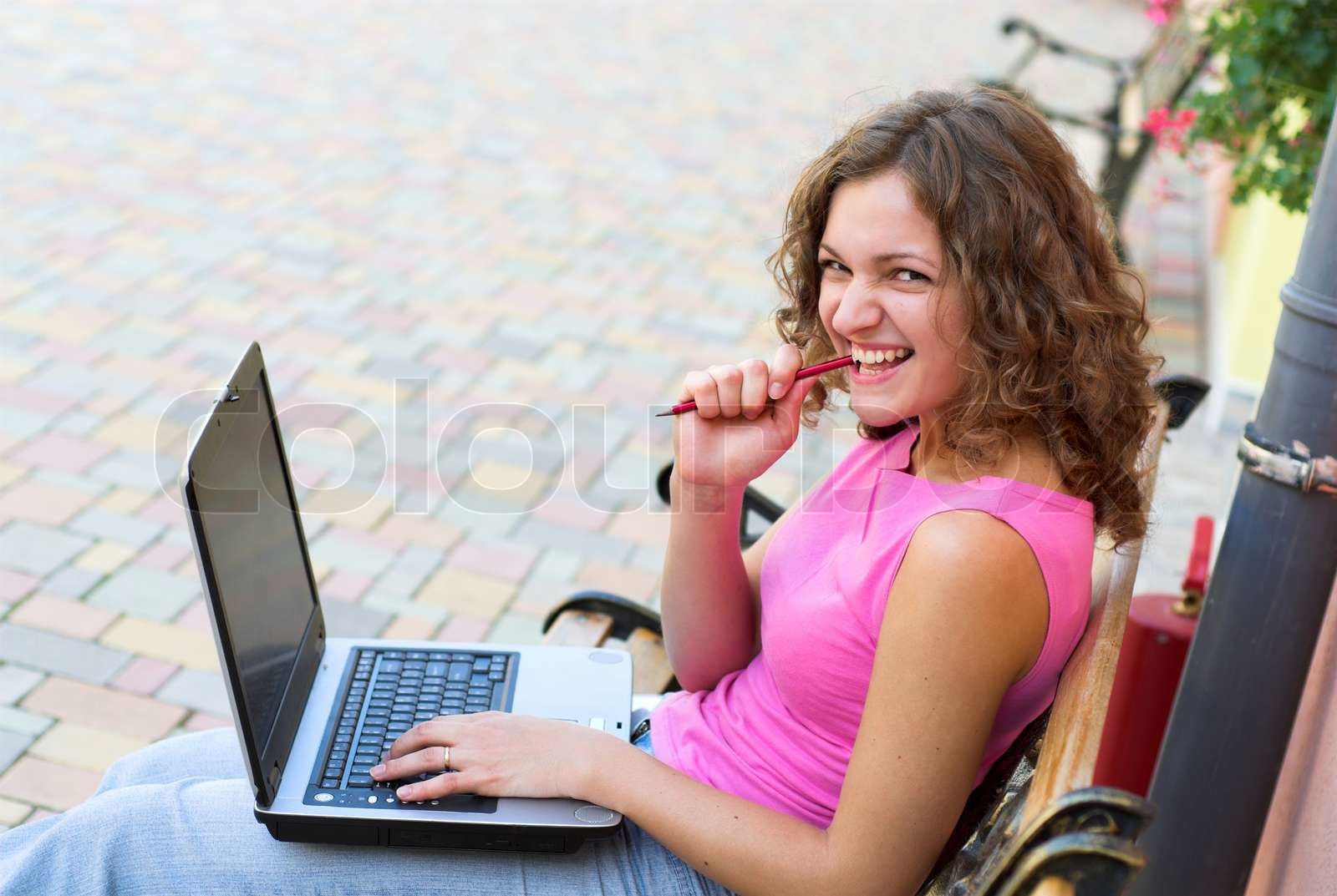 Young female student is eating her pencil | Stock image | Colourbox