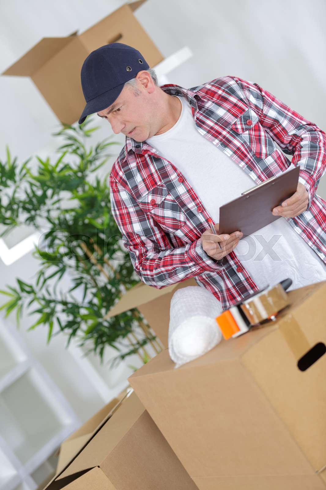 middle age man packing cardboard box with sellotape - Stock Image ...