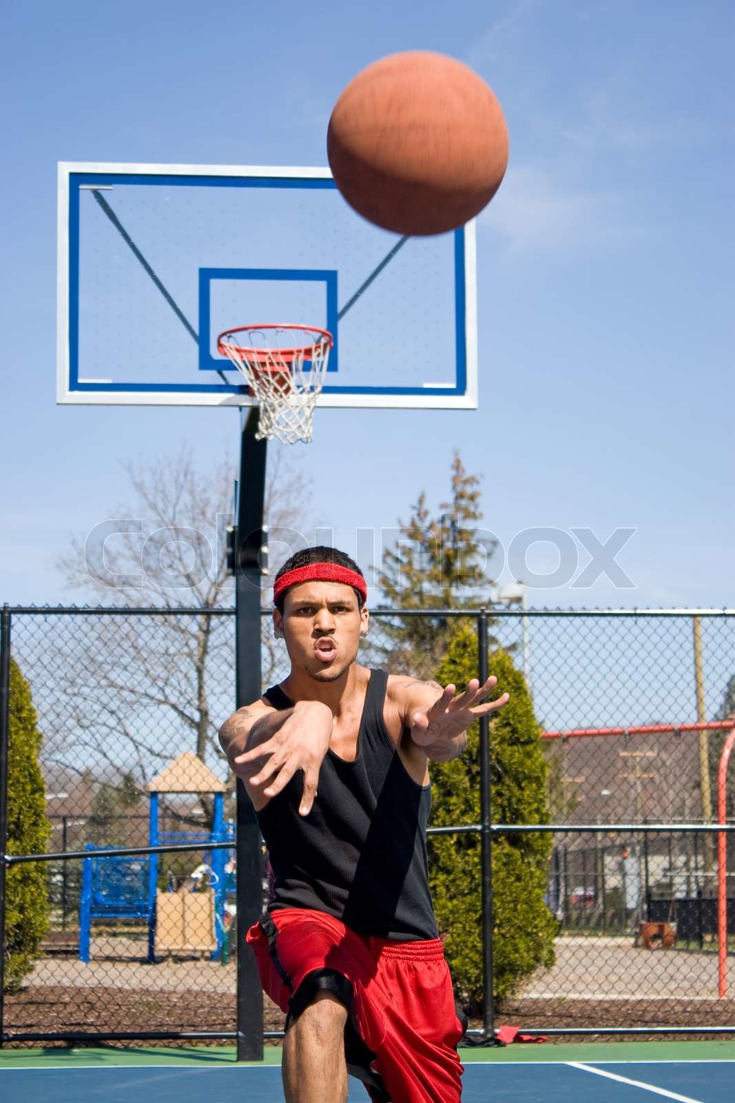 A young basketball player passing the ball across the court | Stock ...