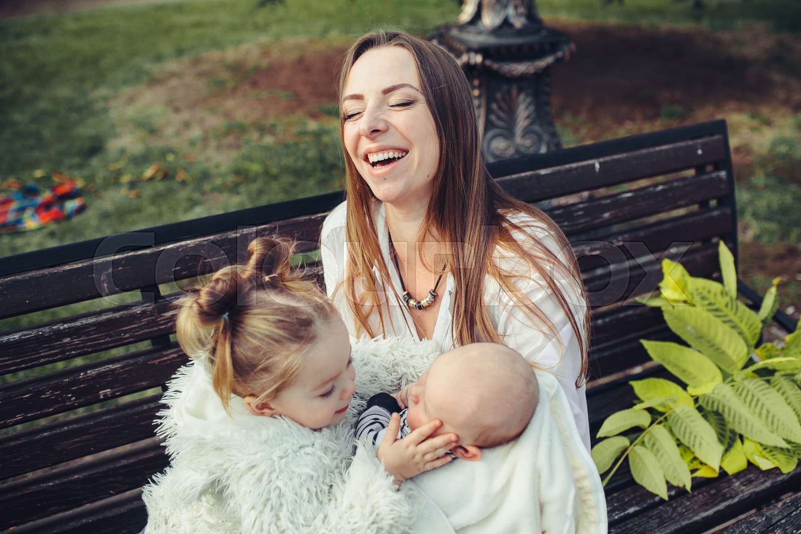 mother and two daughters rest on a bench | Stock image | Colourbox