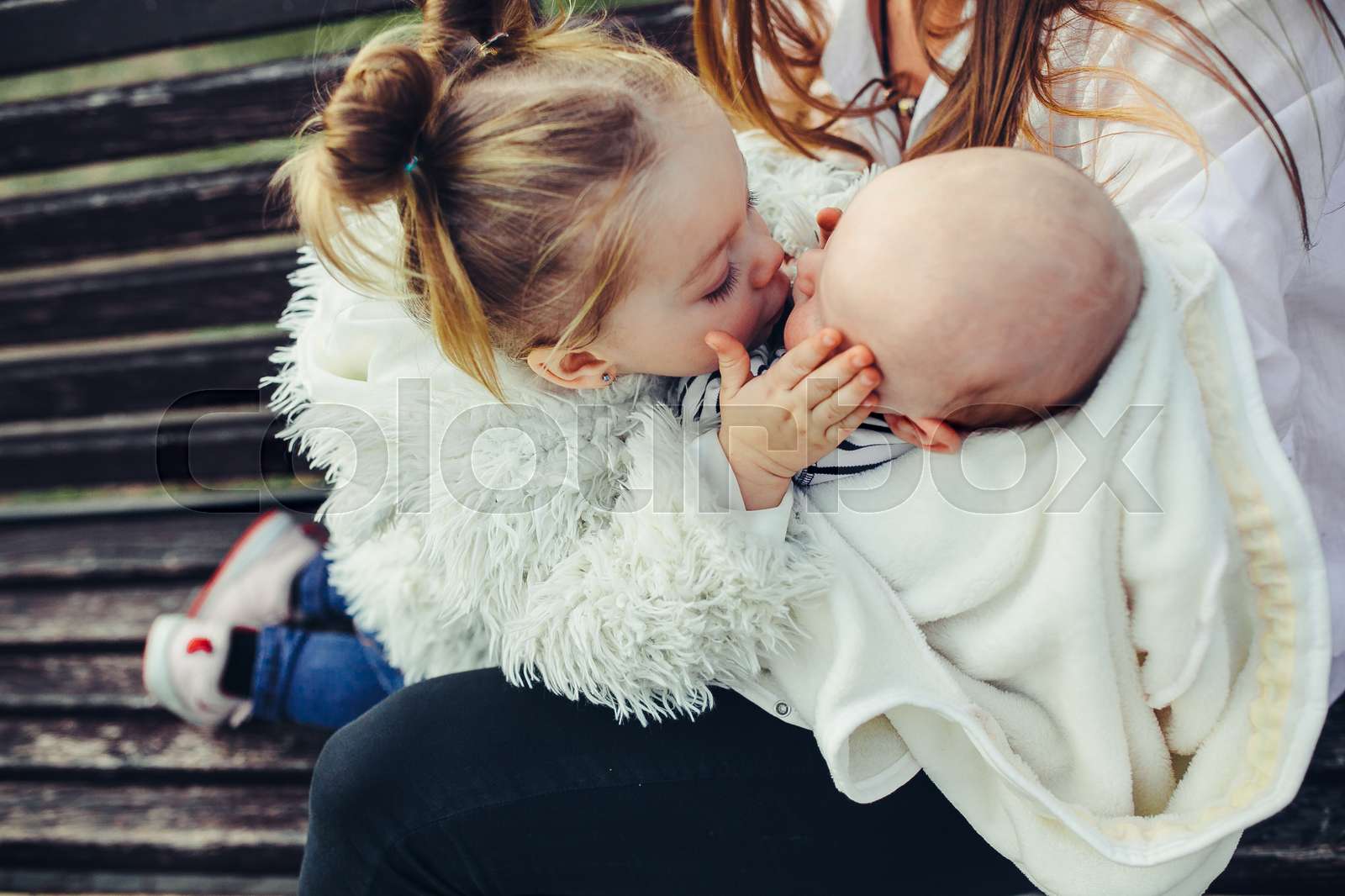 mother and two daughters rest on a bench | Stock image | Colourbox