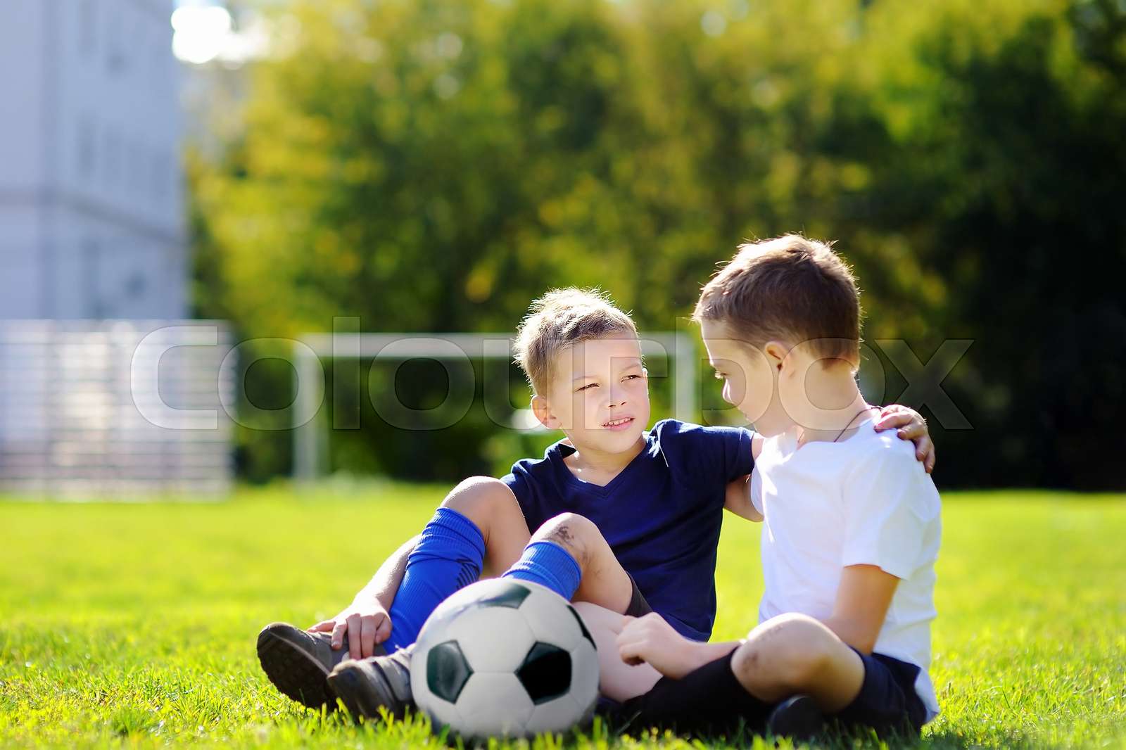 Two little brothers having fun playing a soccer game | Stock image ...