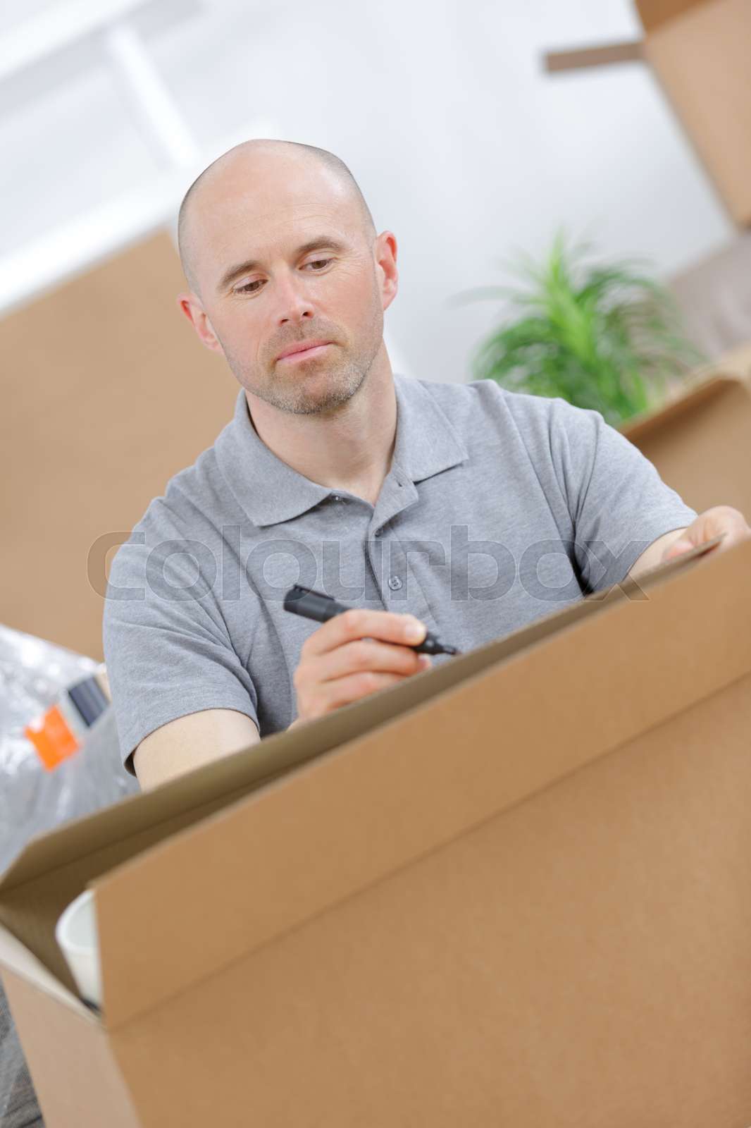 young man packing cartons | Stock image | Colourbox