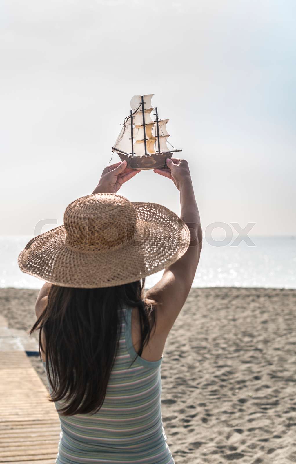 Woman hold boat model on the beach | Stock image | Colourbox