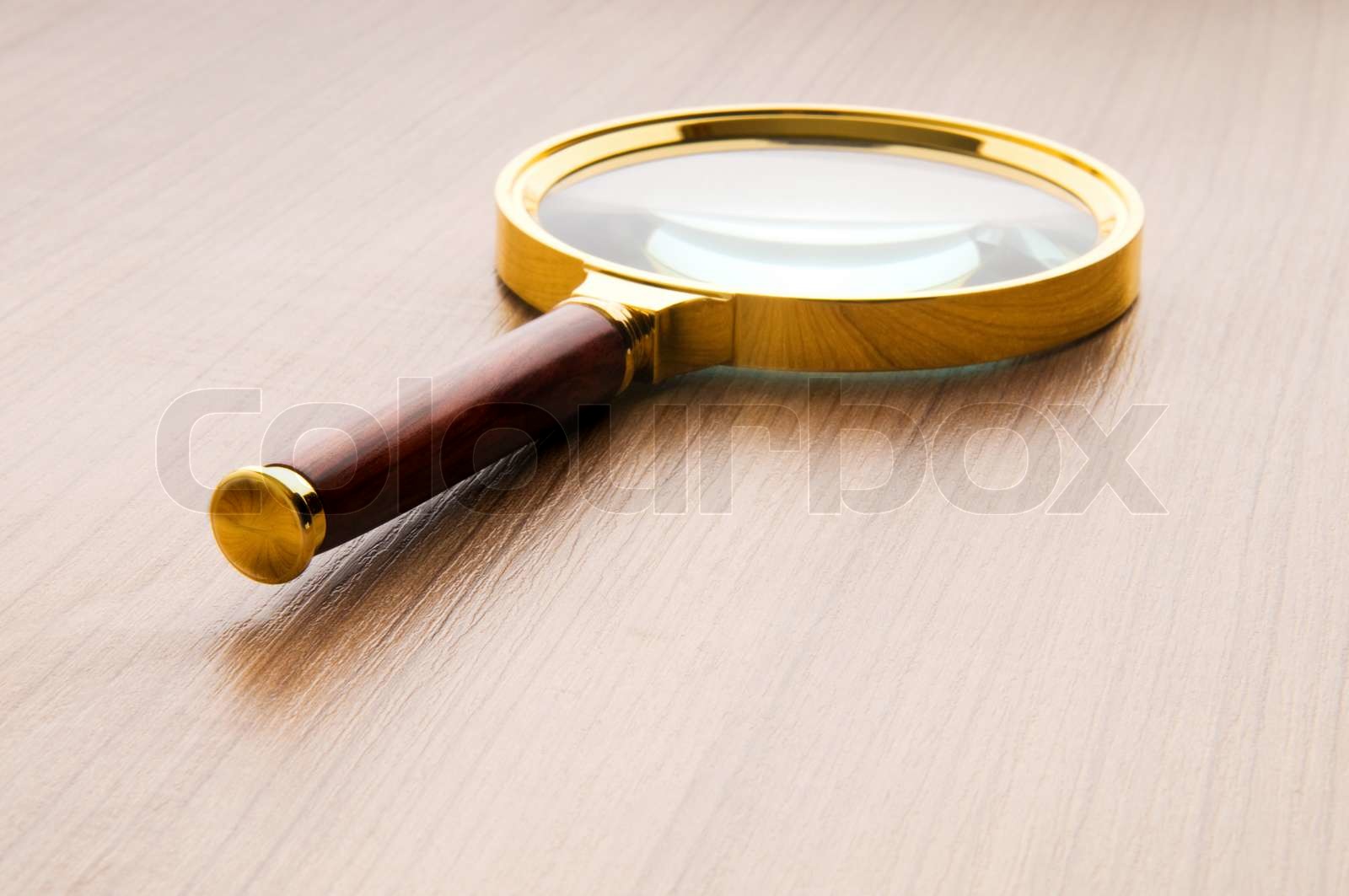 Magnifying glass with wooden handle on the flat surface | Stock image ...
