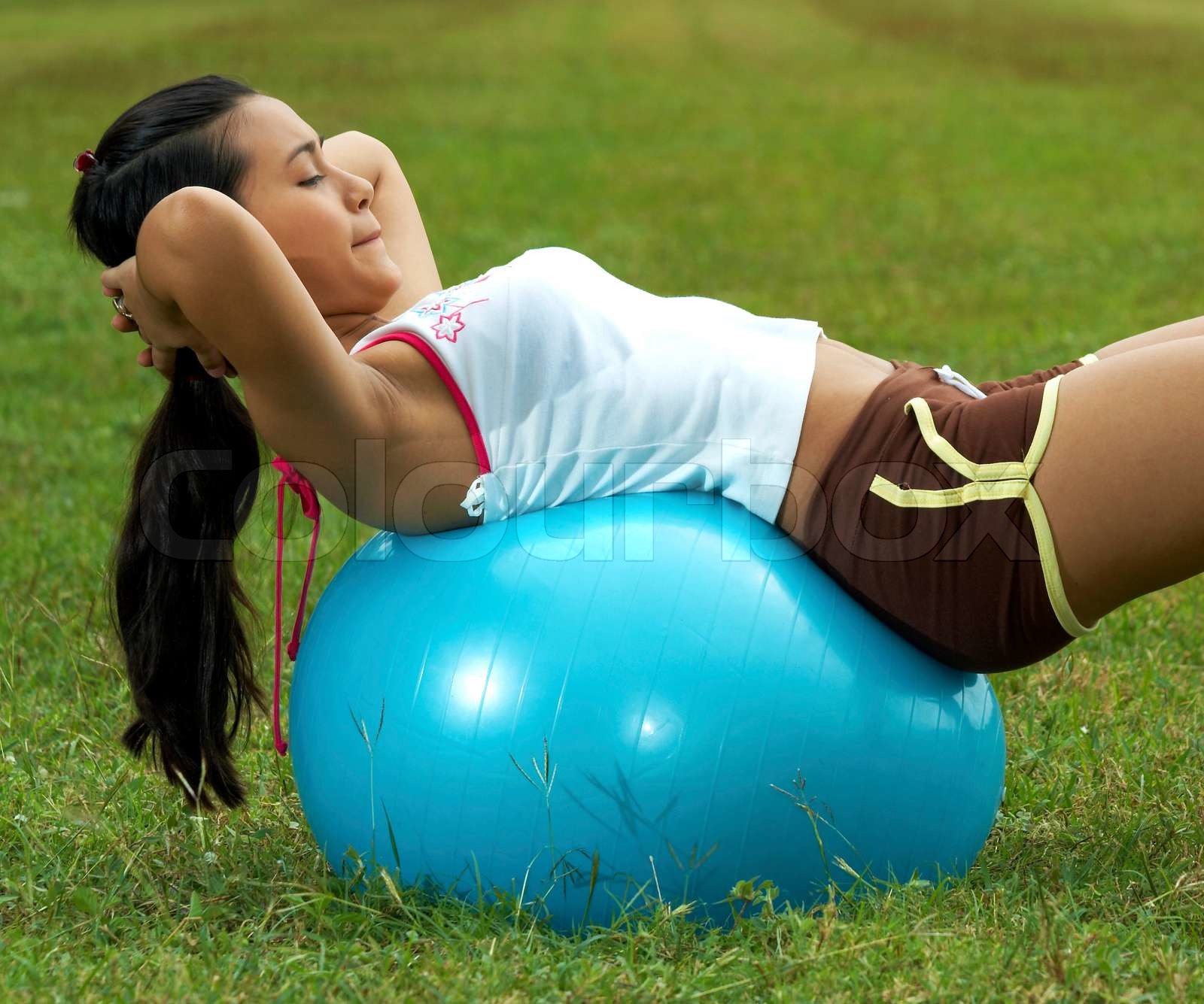 Doing Exercise In The Park Using An Exercise Ball | Stock image | Colourbox