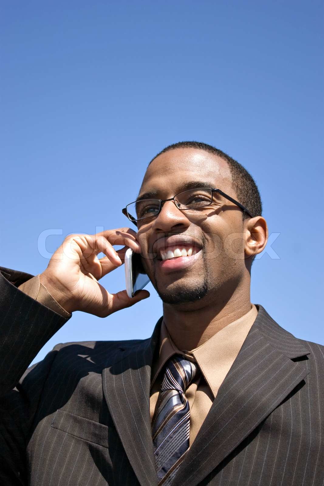A young business professional talking on his wireless mobile phone ...