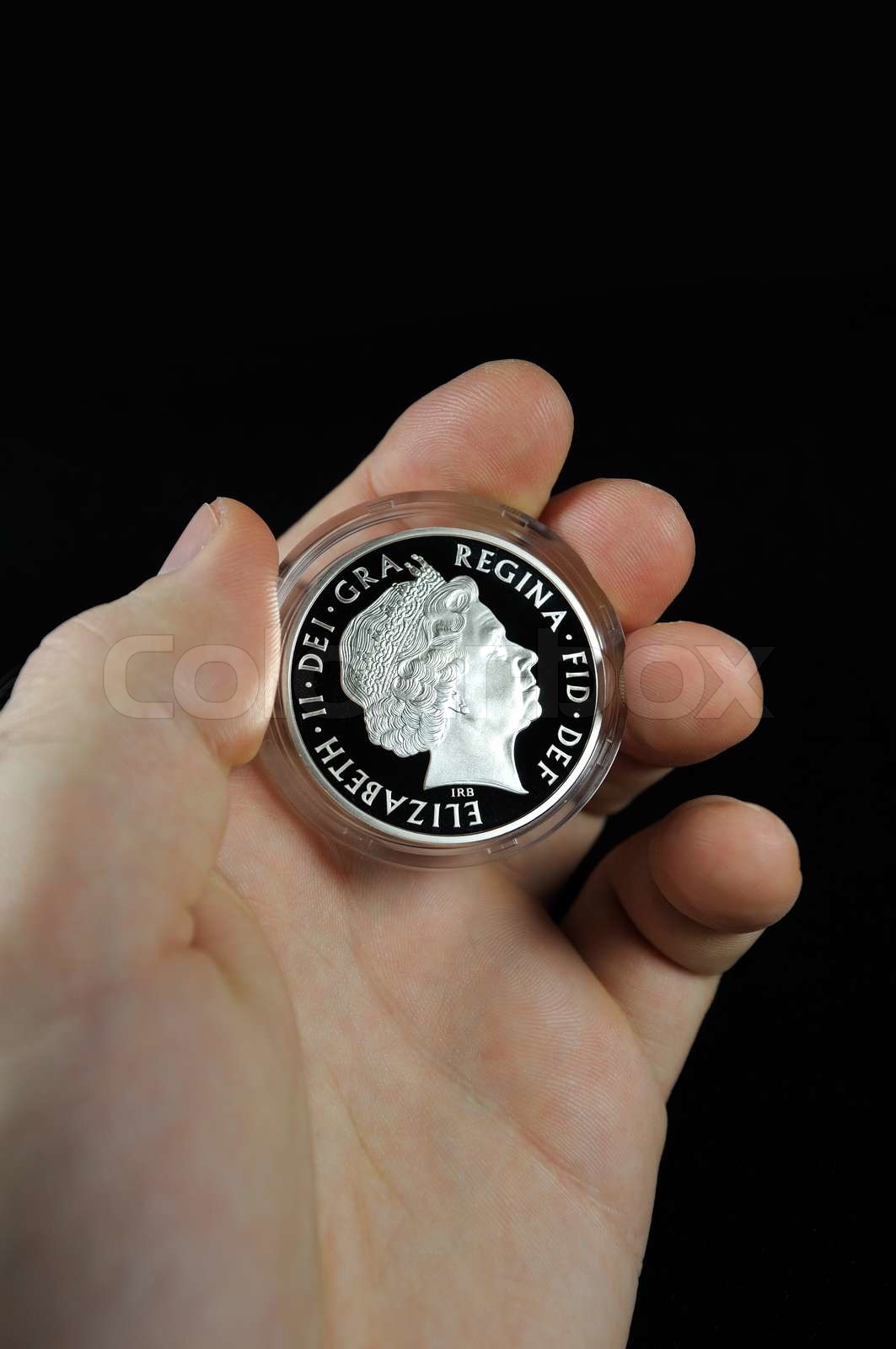 This photograph represents a man holding rare British one pound coin ...