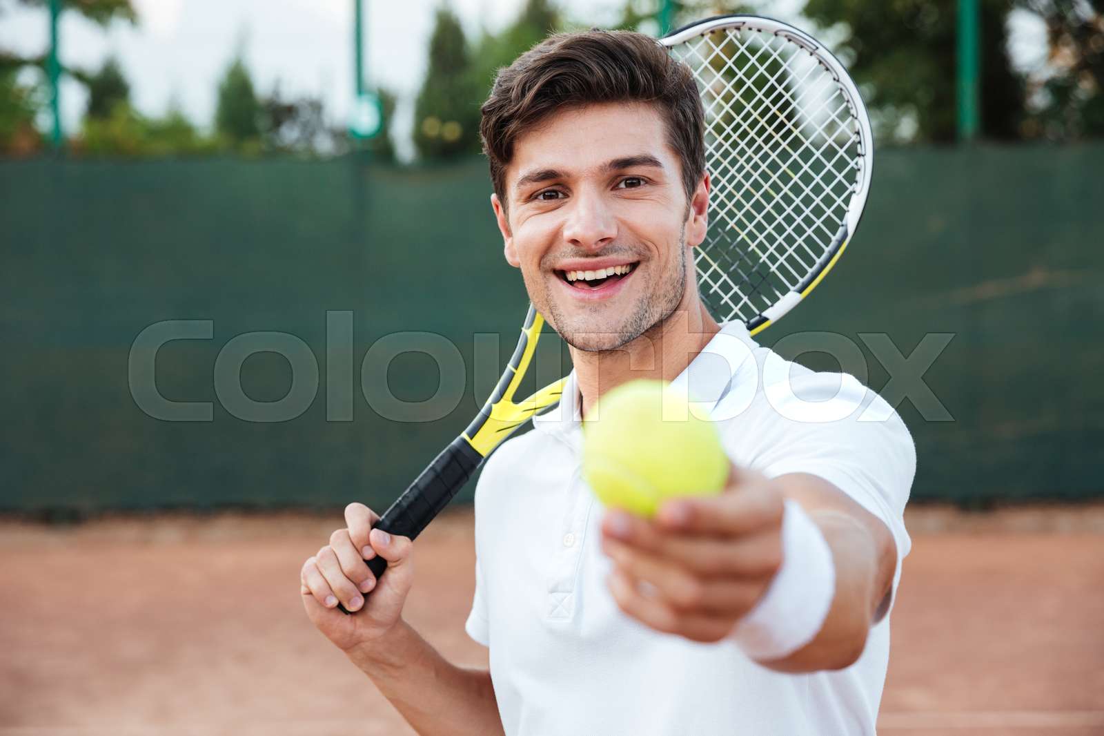 Tennis man giving ball | Stock image | Colourbox