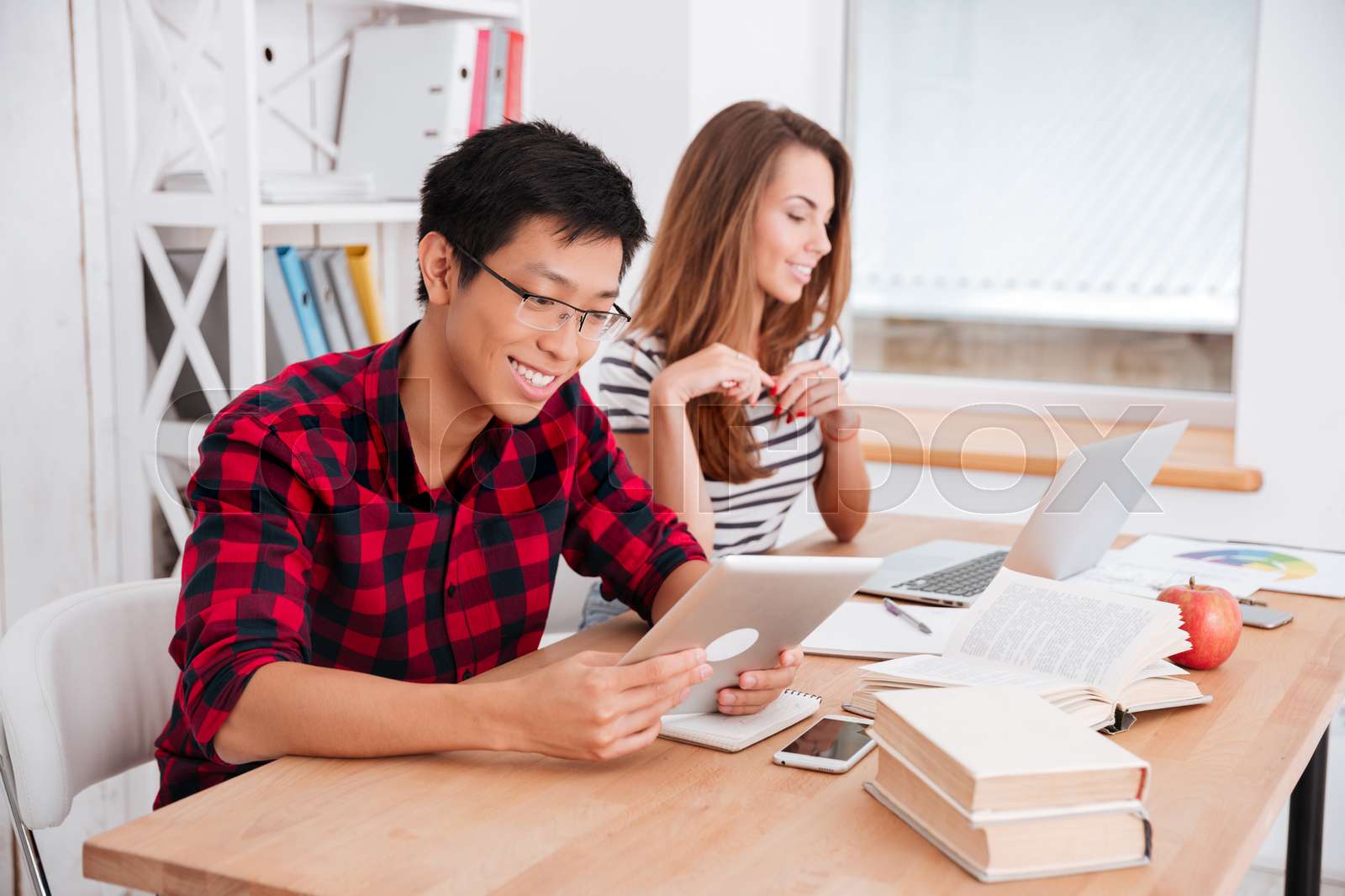 Students working for project in classroom with laptop and tablet ...